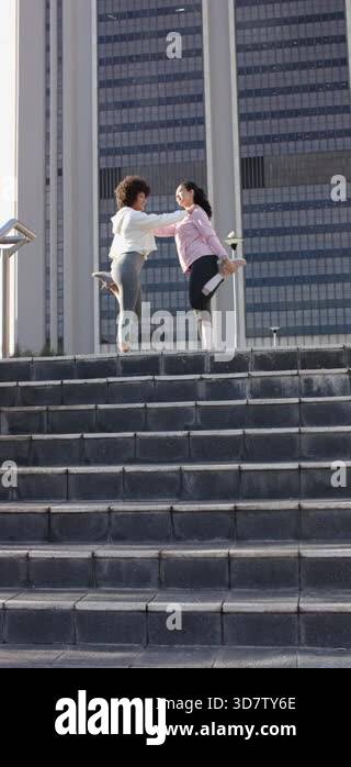 Vertical video: Diverse female friends stretching thighs by lifting ...