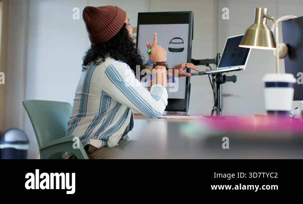 Mid adult man at office reviewing monitor graphic, adjusting stand ...