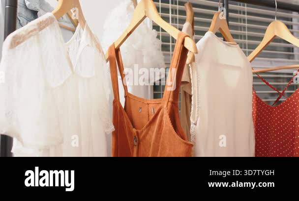 wooden hangers on metal rack swaying clothes against shop blinds ...