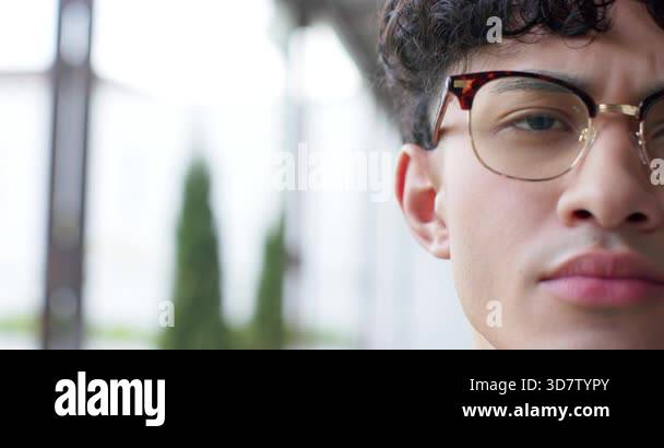 Man holding forward gaze by window with glasses blinking slowly and ...