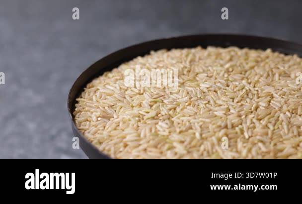 Close up macro video showing rice grains slowly rotating on a dark ...