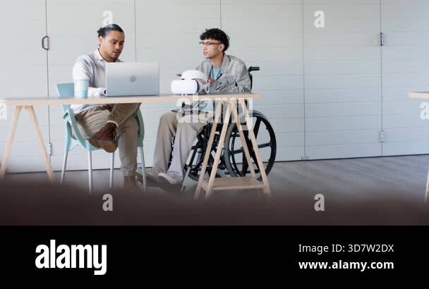 Explaining concept on laptop, male coworkers testing VR headset at ...