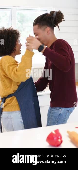 Vertical video: On cue couple dancing and twirling across kitchen ...