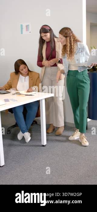 Vertical video: Meeting driving Diverse female team at desk writing ...