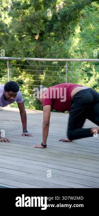 Vertical video: Diverse male friends starting workout doing push-ups ...