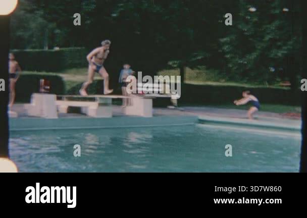 Vintage 8mm slow-motion film of a man diving into a swimming pool from ...