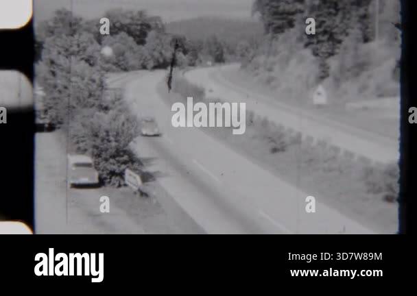 Vintage 8mm black and white footage captures cars moving smoothly along ...