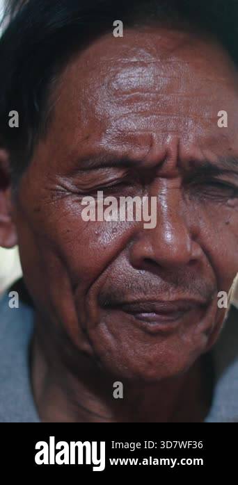 Close-up face and hands of Asian senior man focused on smartphone use ...