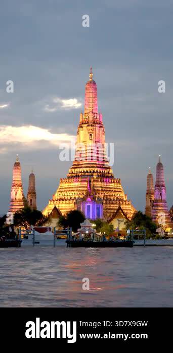 Golden light illuminates Wat Arun, also known as the Temple of Dawn, as ...