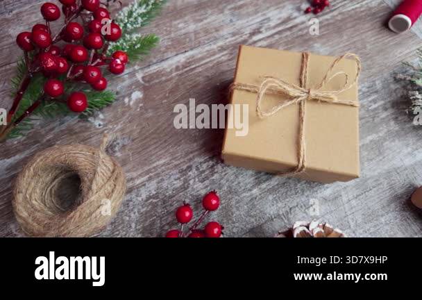 Slow motion flat lay video of a wrapped kraft paper gift on a rustic ...