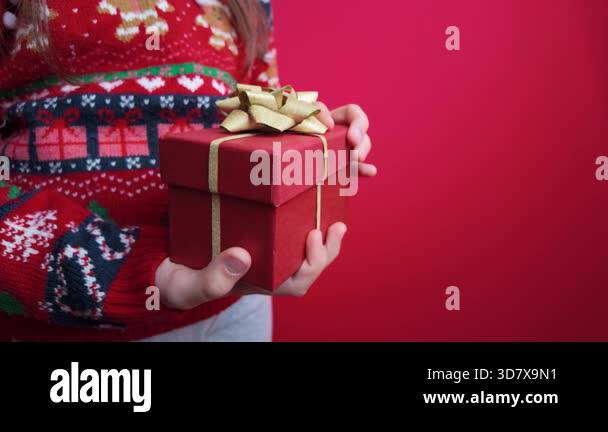 Slow motion shot of a girl opening a wrapped gift box from an alternate ...
