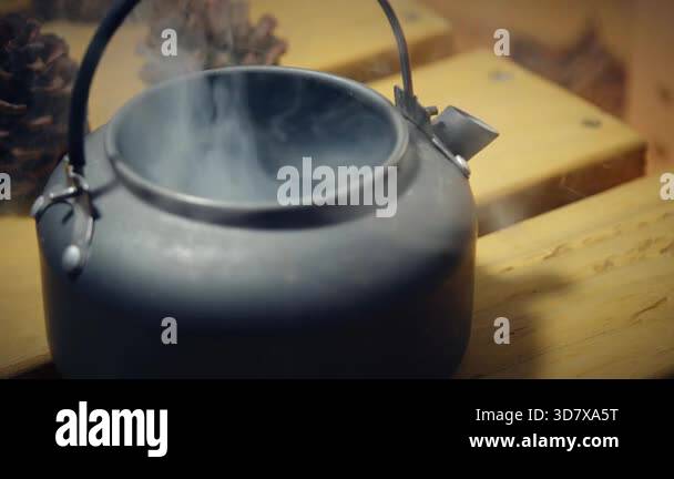 Steam from boiling hot water in camping kettle close up 4k shot slow ...