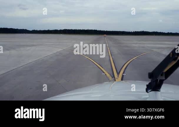 Cockpit view from a small aircraft taxiing along an airport taxiway. A ...