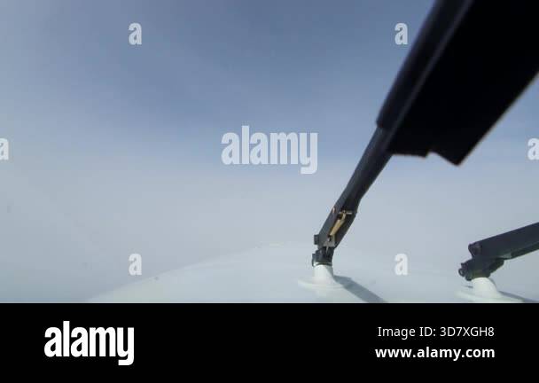 POV cockpit view: aircraft passes through dense white cloud, emerging ...