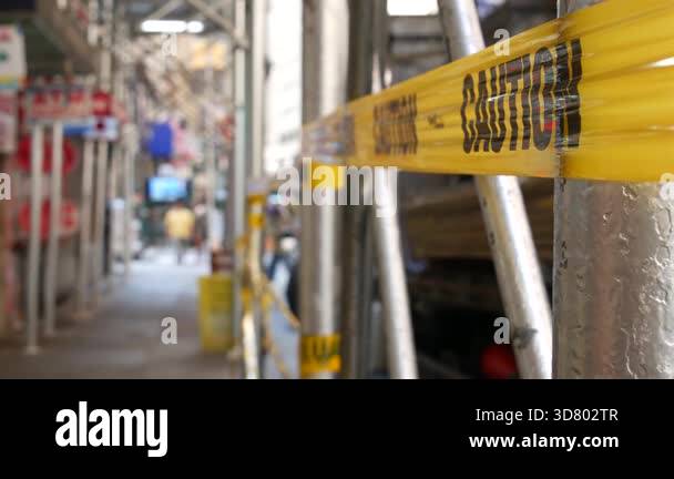 Caution yellow tape and scaffolding on pavement under construction in ...