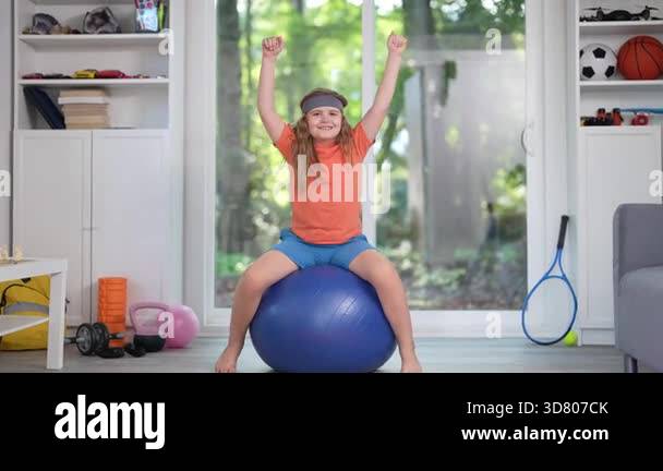 Kid exercising on fitness ball. Child doing fun workout. Kid balancing ...