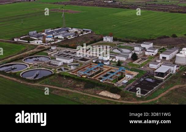 A large wastewater treatment facility is visible in a rural landscape ...