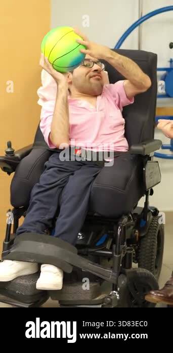 Young man with a physical disability playing with a ball during a ...