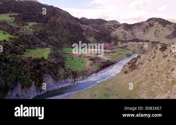 Aerial journey over a tranquil river valley surrounded by lush green ...