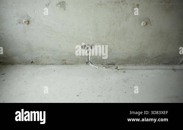 Exposed conduit bends from floor into two junction wells, two porcelain ...