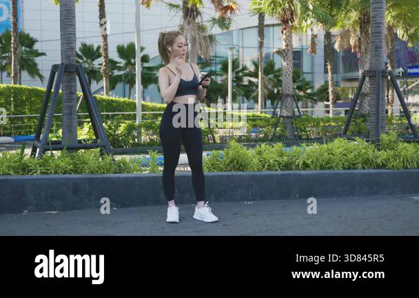 Young woman athlete enjoying lifestyle sport exercise in city, checking ...