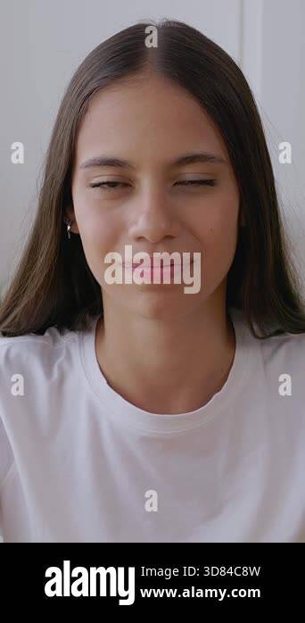 Vertical HD video of smiling young teenage girl sitting at table at ...