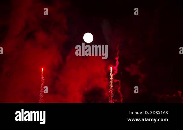 Fireworks rising in red smoke under full moon in dark night sky Stock ...