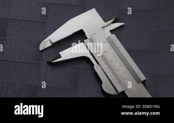 Caliper measuring device rotating on black textured background Stock ...