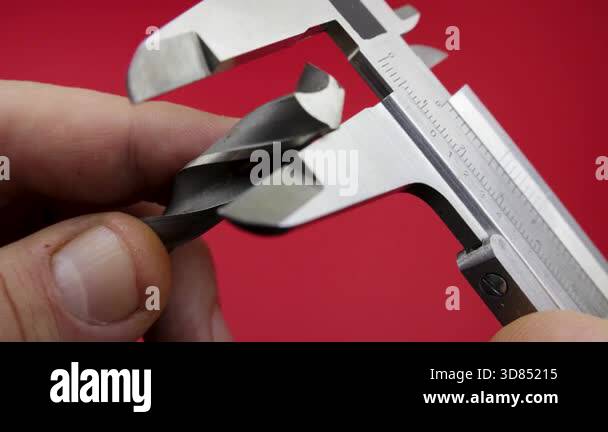 Drill bit measuring using caliper Woodworking Red background Stock ...