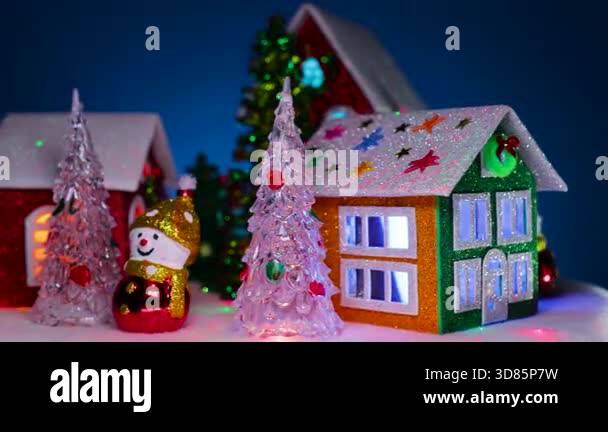 A close-up of a rotating Christmas village with houses with bright ...