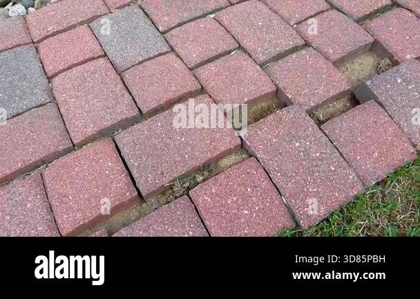 Slow motion- A close-up view shows an uneven section of red brick ...