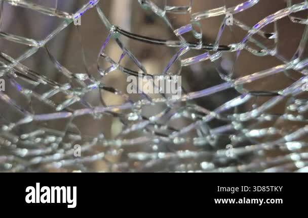 Broken cracked glass in closeup with pieces still intact shows a ...