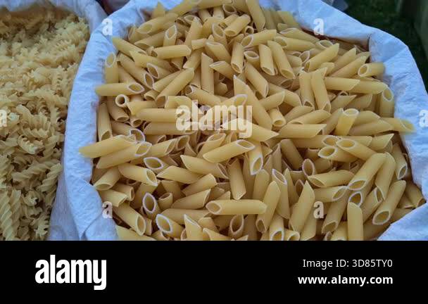 Raw pipe and screw pasta types are arranged in piles for sale at a ...