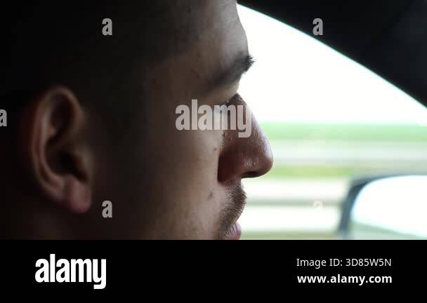 Focused male driver in a car, showcasing a side profile view while ...