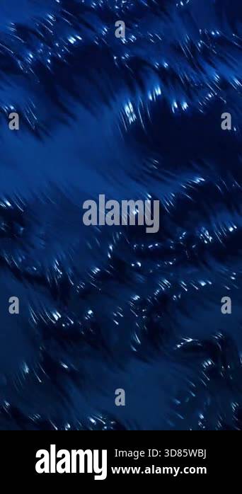Dark blue, glossy paint undulates, slowly creating beautiful, flowing ...