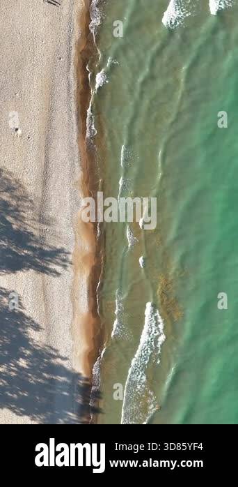 Top-down aerial view of Lake Michigan shoreline with gentle waves on a ...