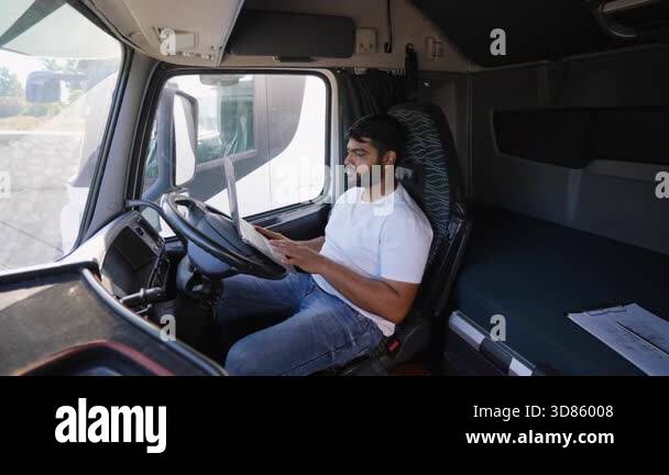 Professional long haul driver of indian ethnicity sitting in the cabin ...