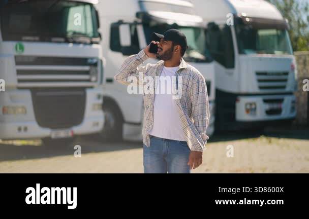 Serious indian truck driver in casual clothes talking on his smartphone ...
