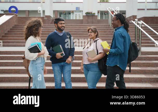 Cheerful group of multiethnic students standing on the stairs of the ...