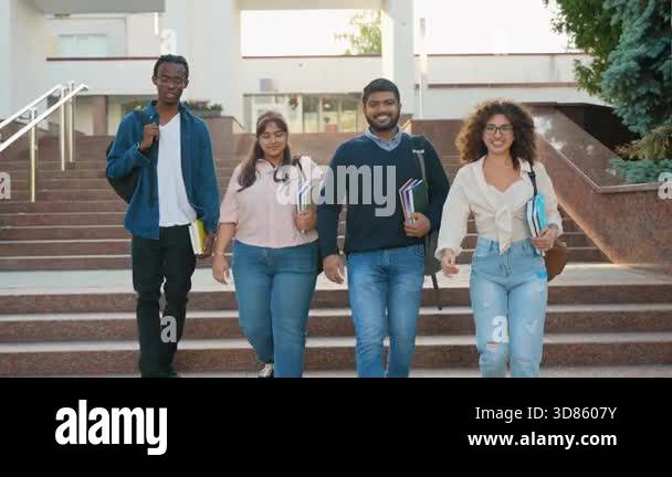 Four smiling multicultural friends and fellow students leaving the ...