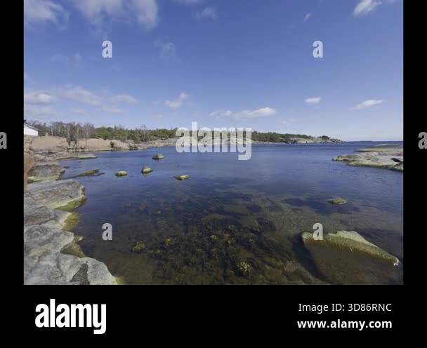 tranquil coastal bay clear water reflections with rocky foreground and ...
