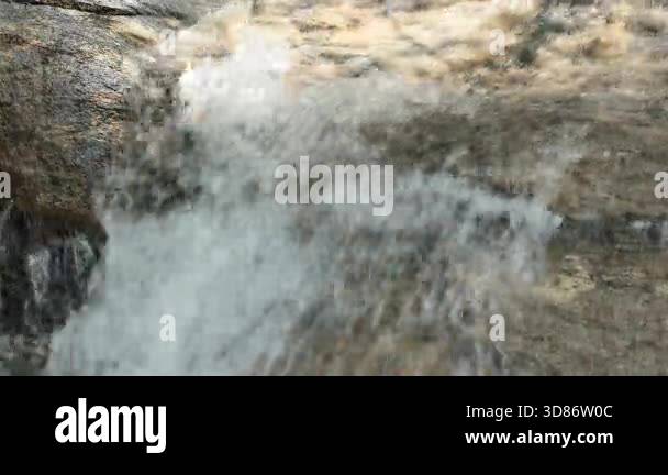 Close-up of waterfall splashing over natural rocks, capturing movement ...