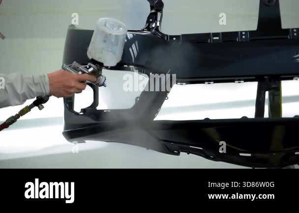 Auto technician spray shine lacquer on car bumper inside clean ...
