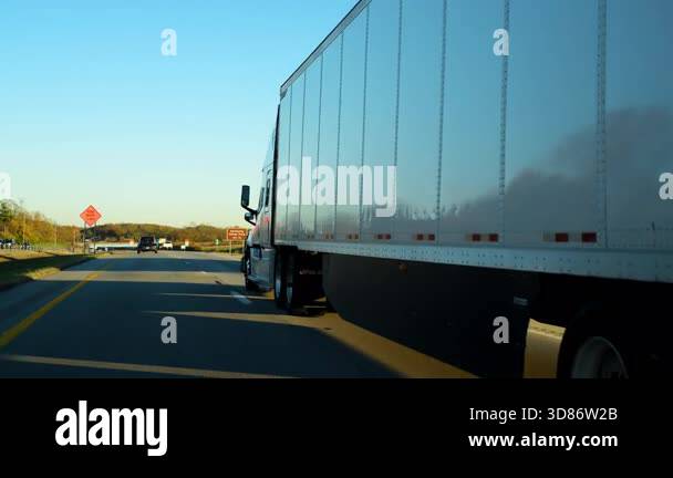 Semi truck hauling cargo along a busy interstate highway on a clear ...