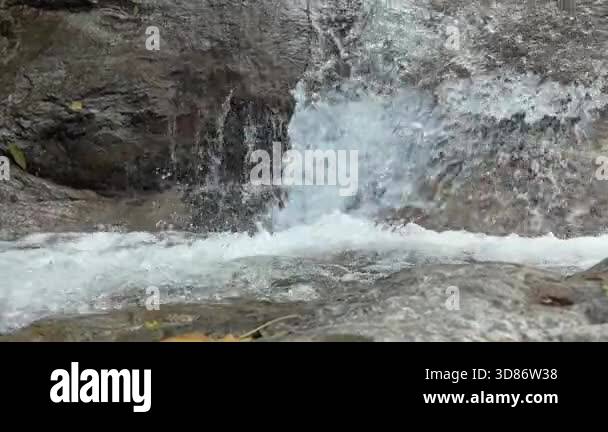 Fresh mountain stream flowing over rocky surface, showcasing natural ...