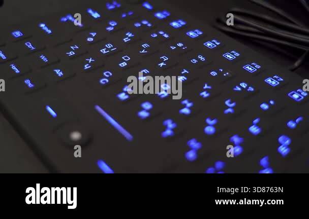 Close-up sliding camera move over blue backlit keyboard. Soft motion ...