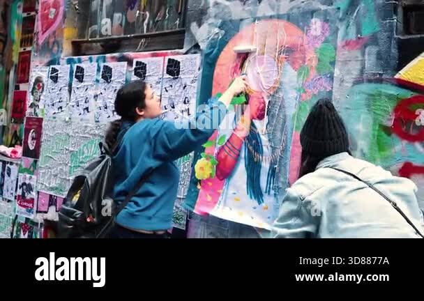 Two artists creating vibrant graffiti mural together Stock Video ...