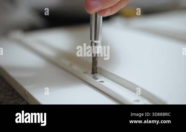 Tightening screw on drawer slide during dresser assembly. Fastening ...