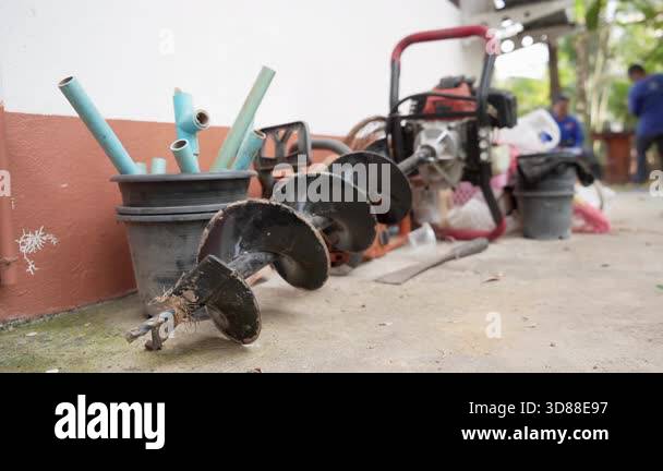 Worker Using Mechanical Ground Drilling Machine on a Construction Site ...