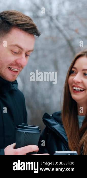 People wearing warm jackets stand outdoors in winter. Couple discusses ...